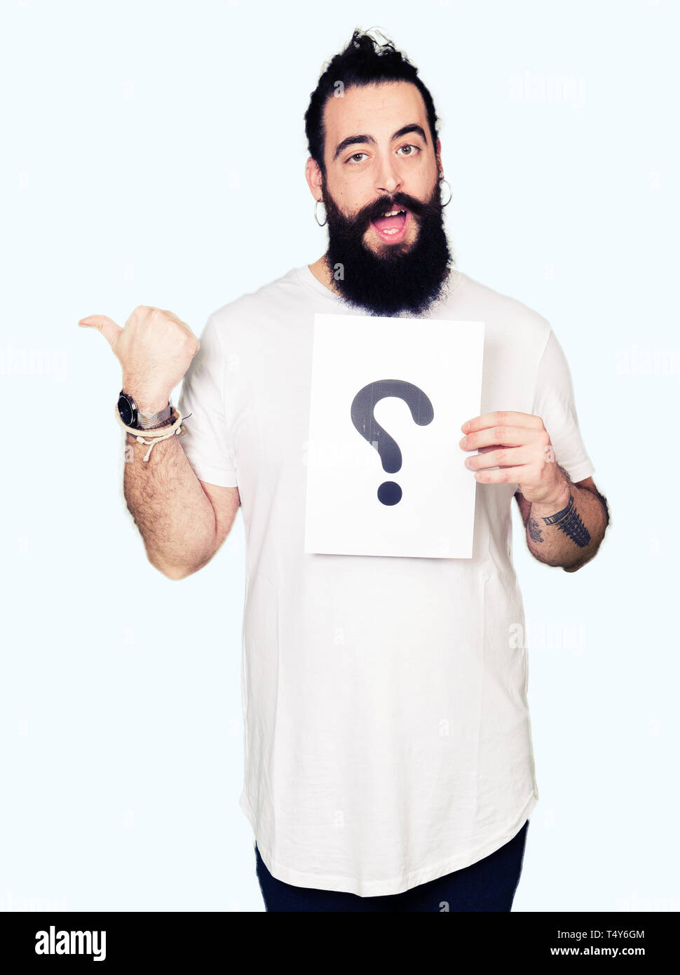 Young man with long hair and bear holding a paper with question mark ...