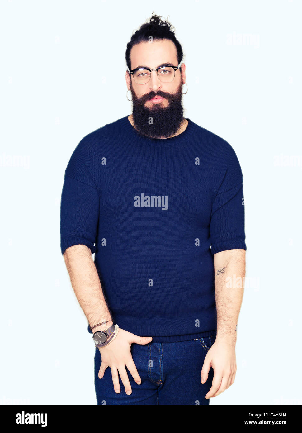 Young hipster man with long hair and beard wearing glasses depressed ...