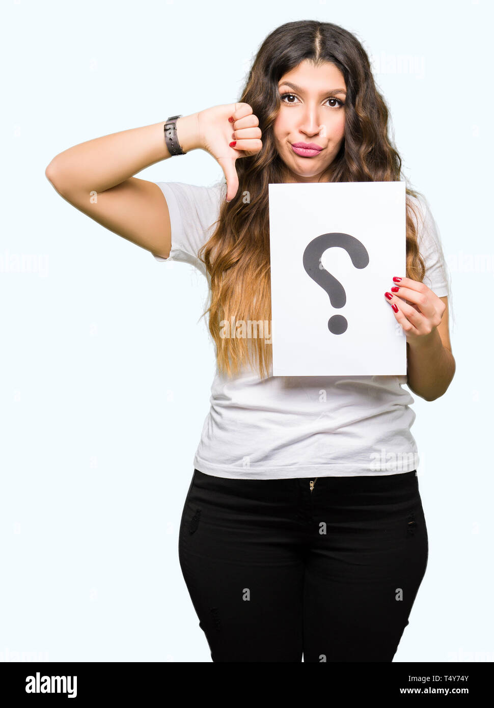 Young adult woman holding paper with question mark with angry face ...