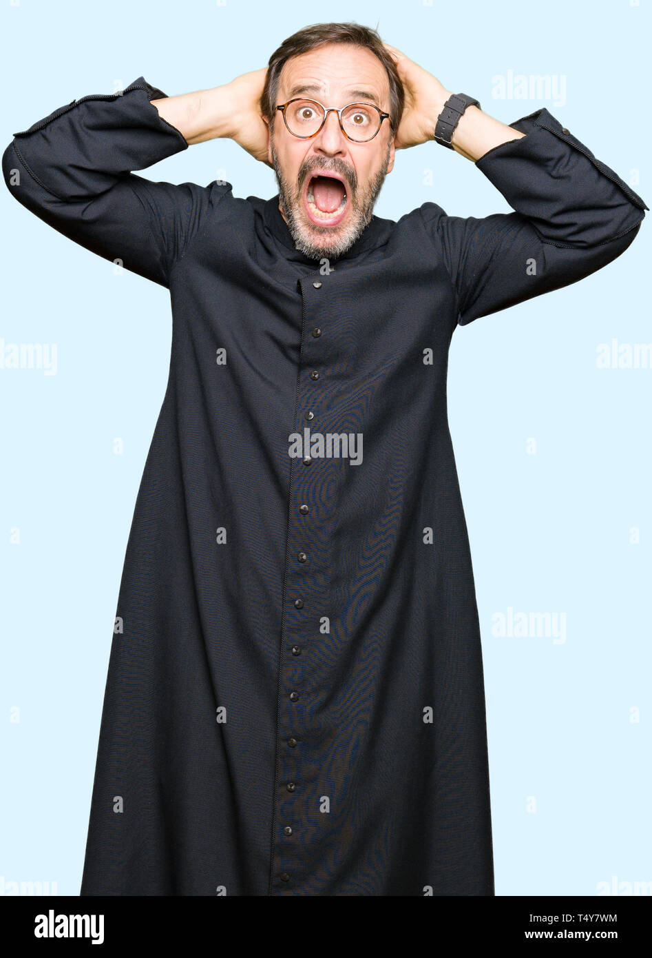 Middle age priest man wearing catholic robe Crazy and scared with hands ...