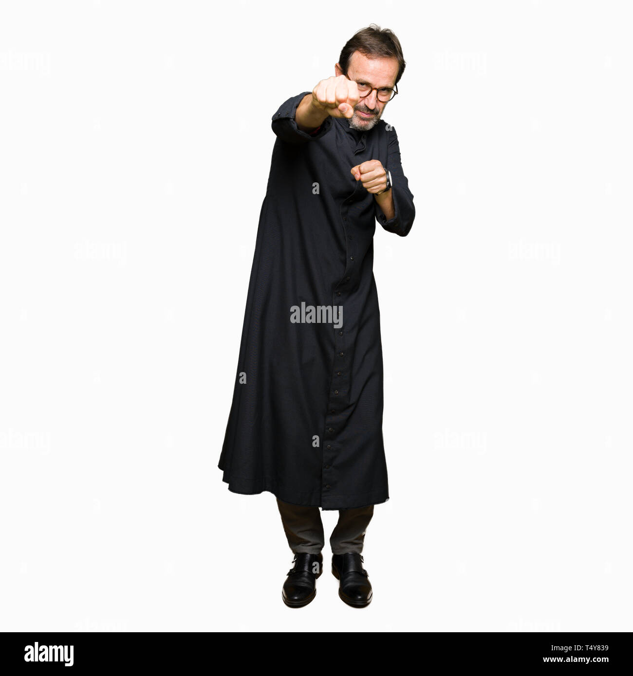 Middle age priest man wearing catholic robe Punching fist to fight ...
