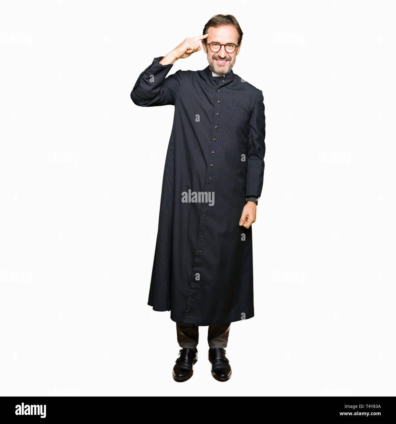 Middle age priest man wearing catholic robe Smiling pointing to head ...