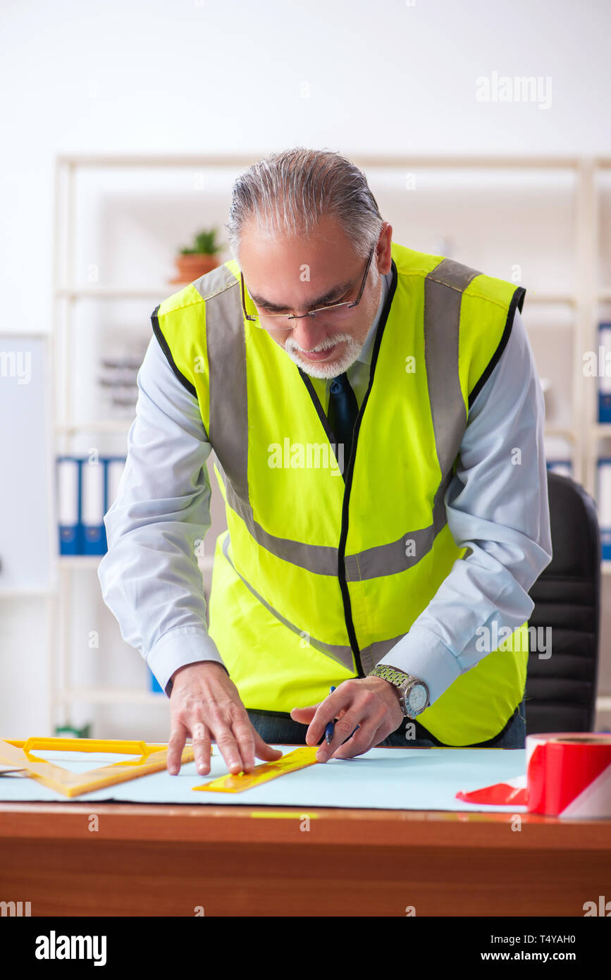 Aged construction engineer working in the office Stock Photo - Alamy