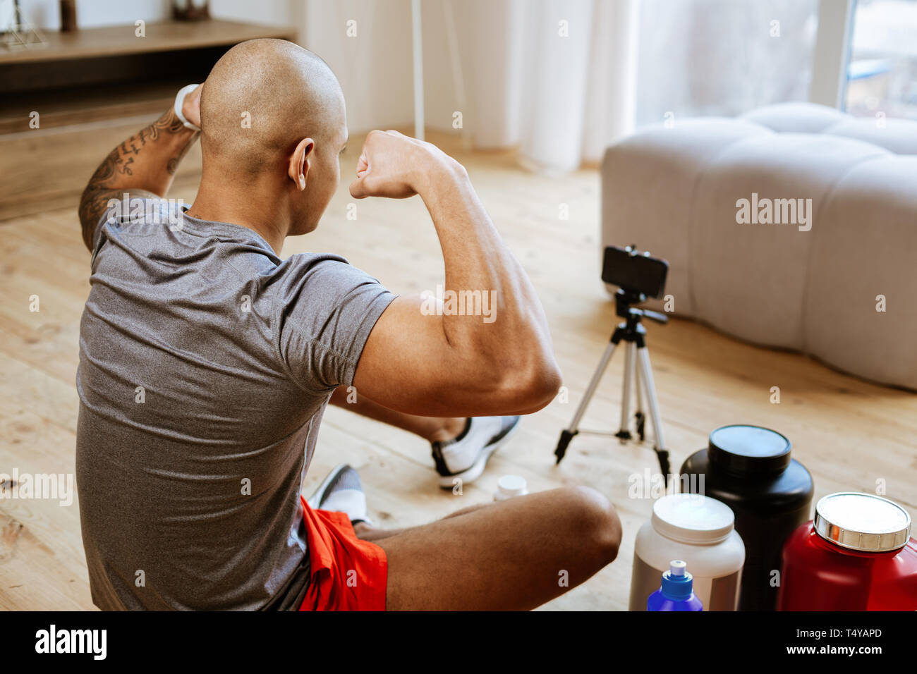 Bodybuilder wearing grey t-shirt and red shorts showing biceps Stock ...