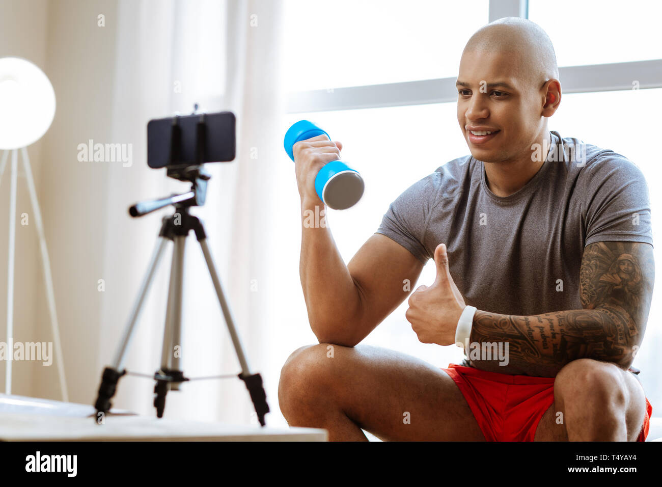 Bald bodybuilder recommending best exercises with dumbbells Stock Photo ...