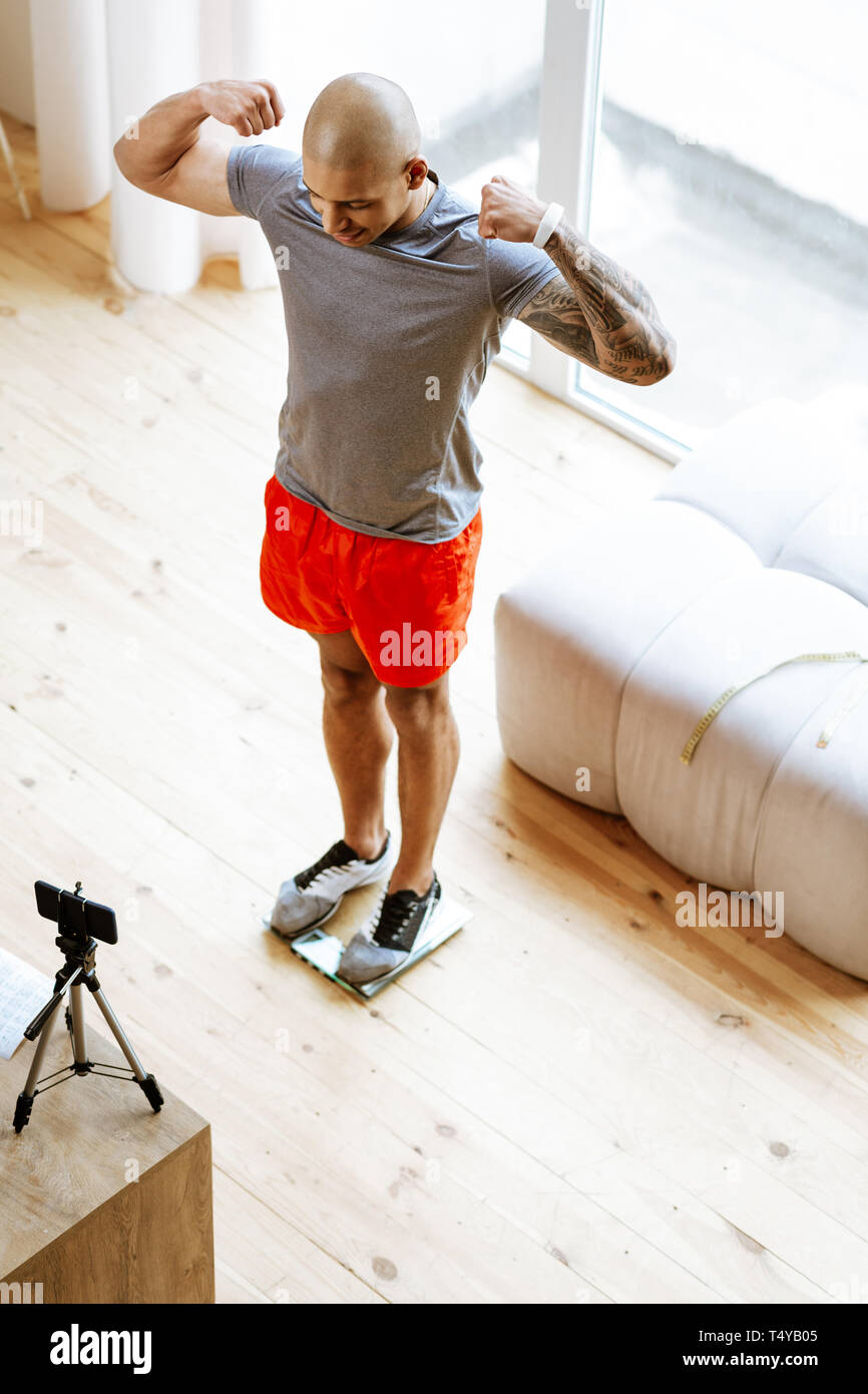 Bodybuilder showing his biceps while standing in front of camera Stock ...