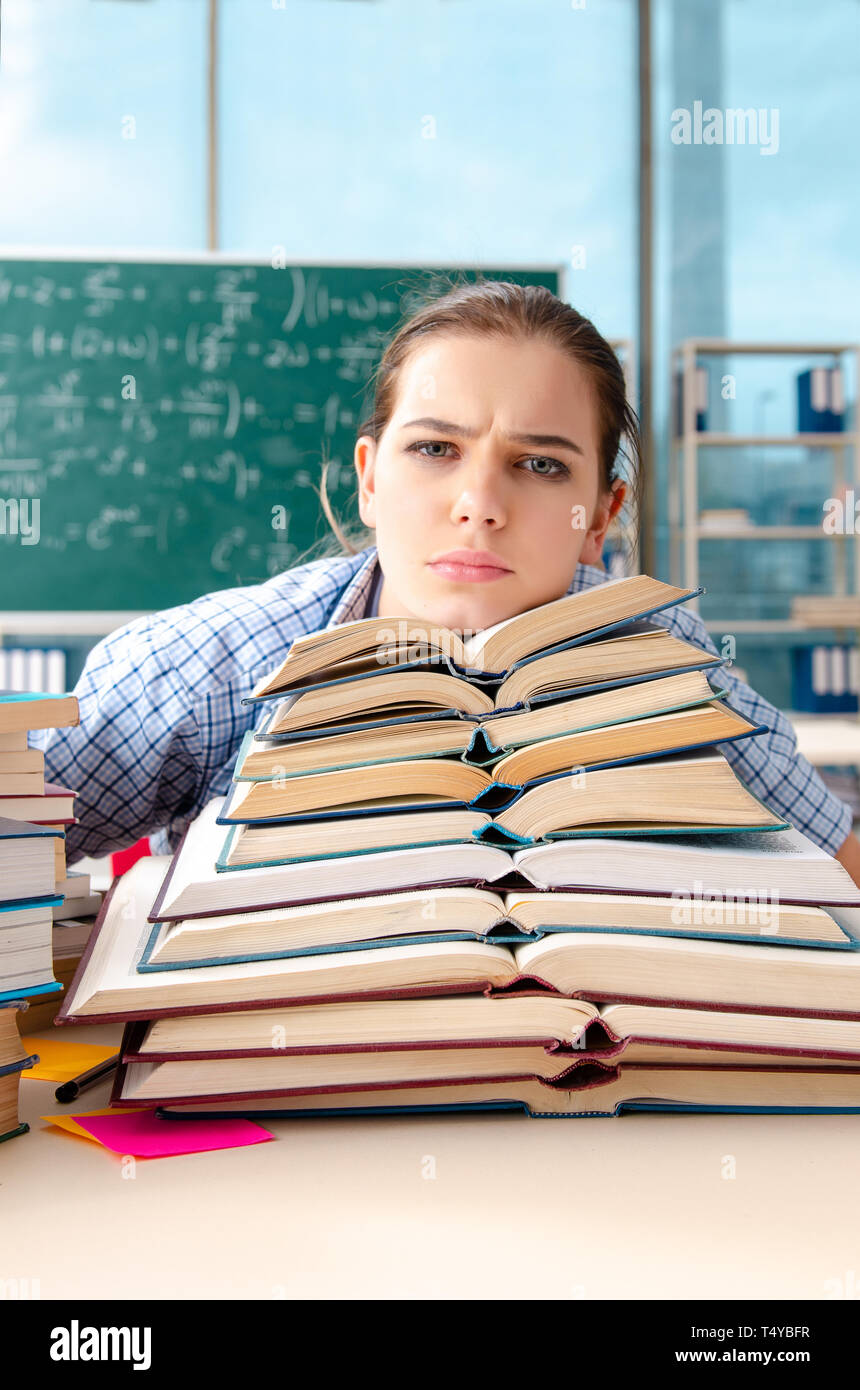 Female student with many books sitting in the classroom Stock Photo - Alamy
