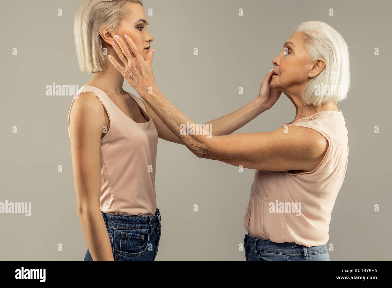 Nice serious women touching each others faces Stock Photo - Alamy