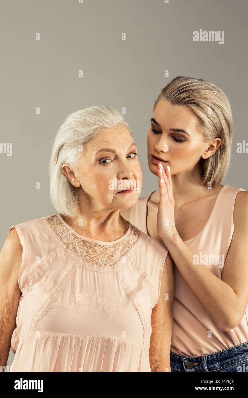 Pleasant good looking young woman telling a secret Stock Photo - Alamy