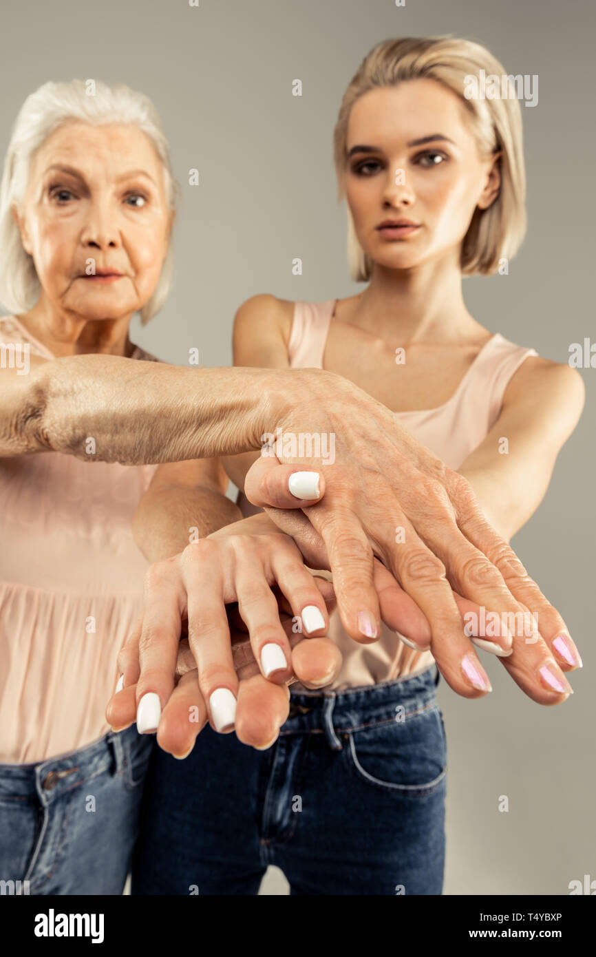 Hands of two women being shown to you Stock Photo - Alamy