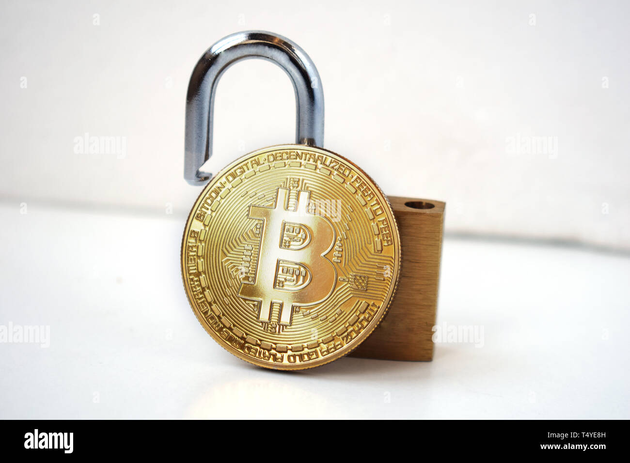 Bitcoin security concept. Gold coin with padlock on a light background ...