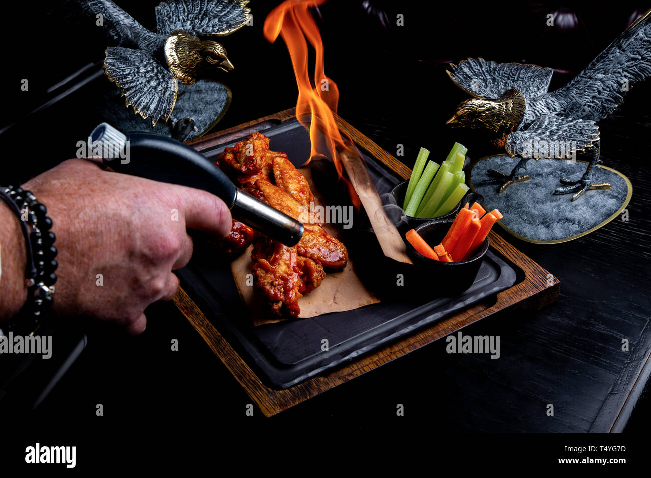 Delicious pieces of chicken wings grilled with Fire flames. On ...