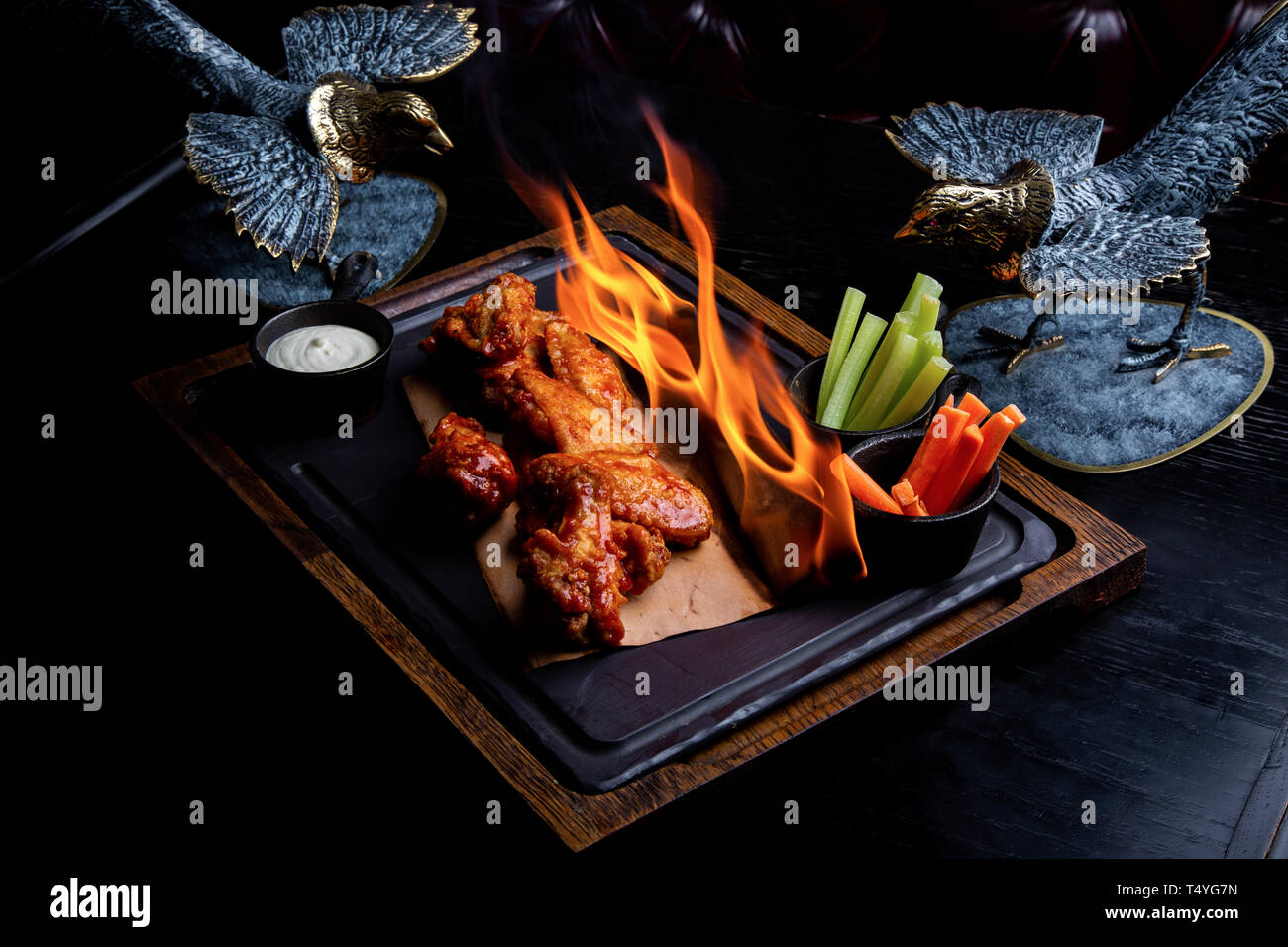 Delicious pieces of chicken wings grilled with Fire flames. On ...