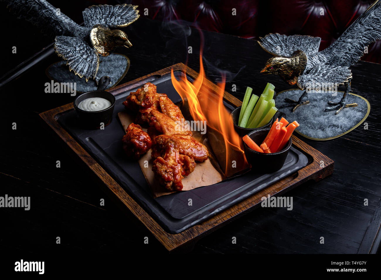 Delicious pieces of chicken wings grilled with Fire flames. On ...