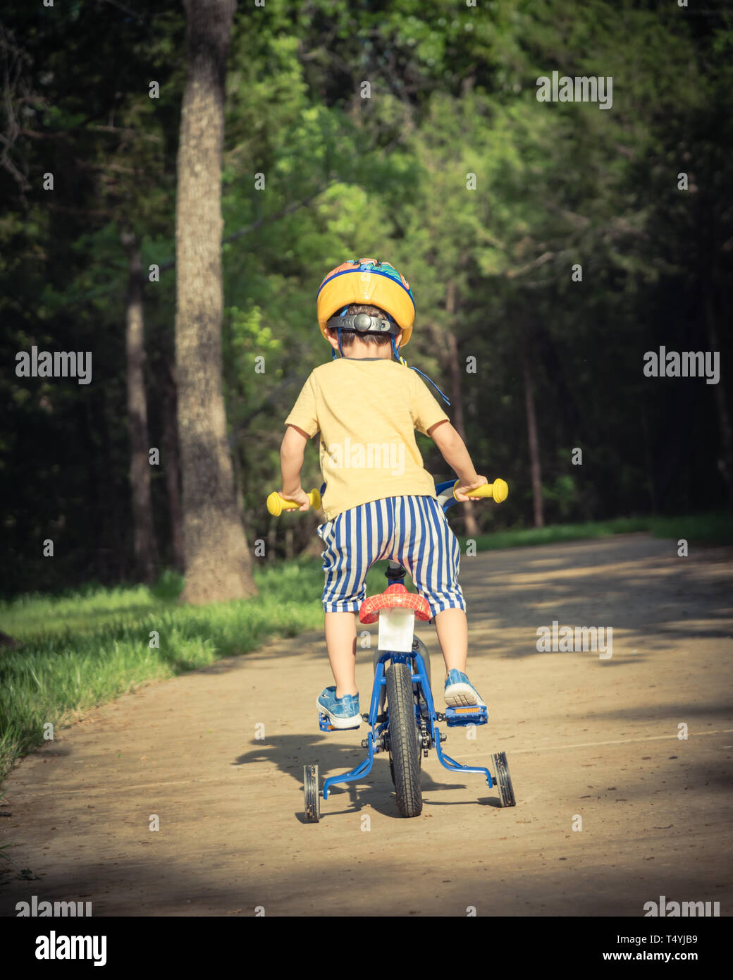 Vintage tone rear view of Asian toddler boy riding tricycle at nature ...