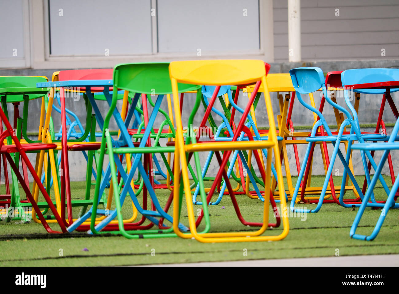 Multi-color steel chair set on green plastic grass In the public ...