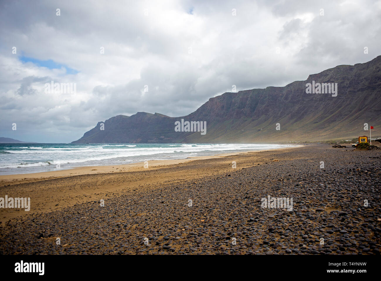 The beach of Famara on the island of Lanzarote in a windy day with grey ...
