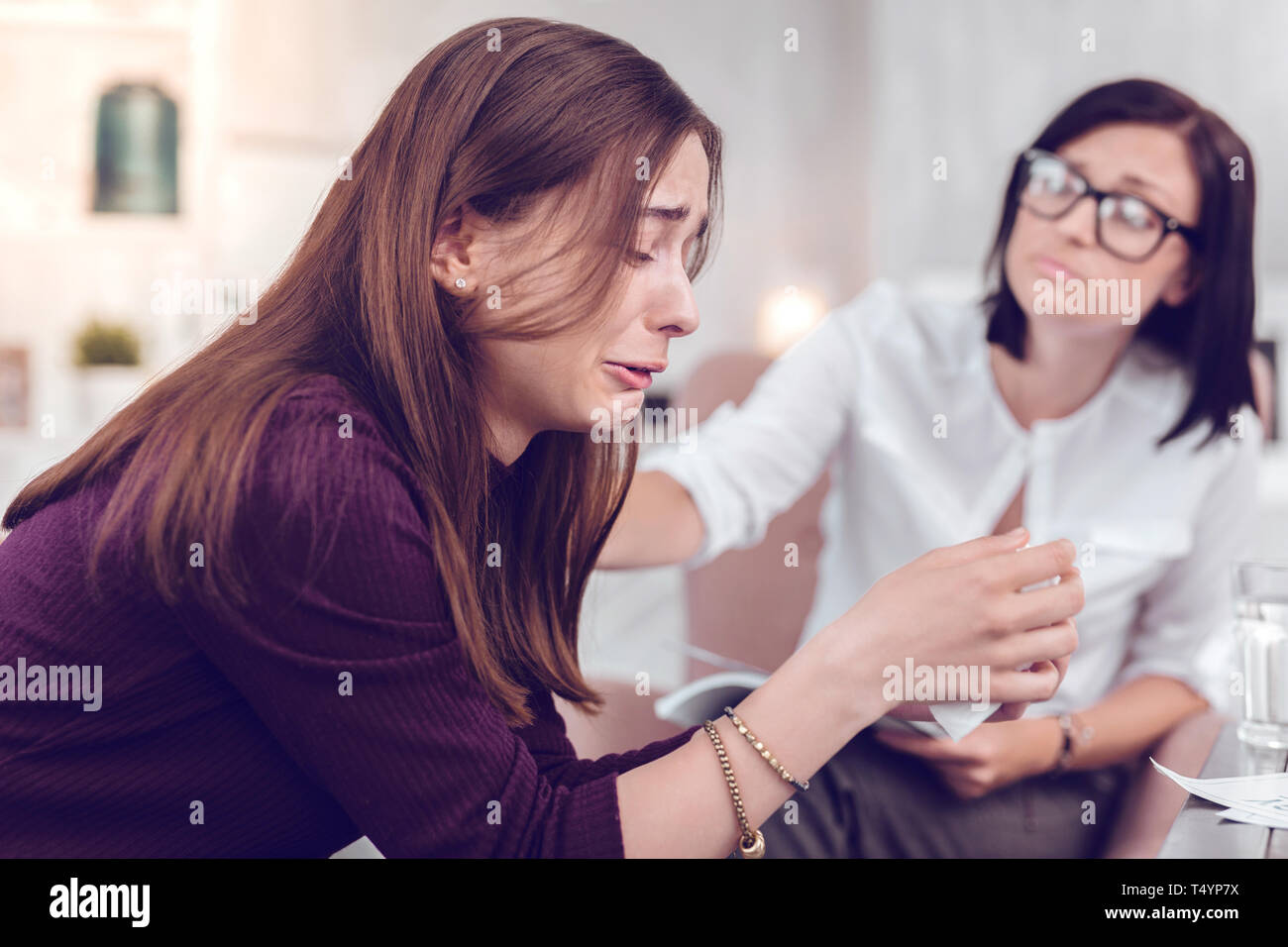 A dark-haired charming counselor comforting crying emotional dark ...