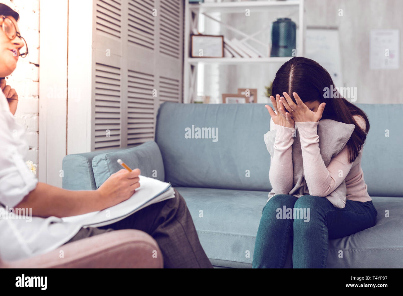 Depressed crushed downhearted brown-haired client having a therapy with ...