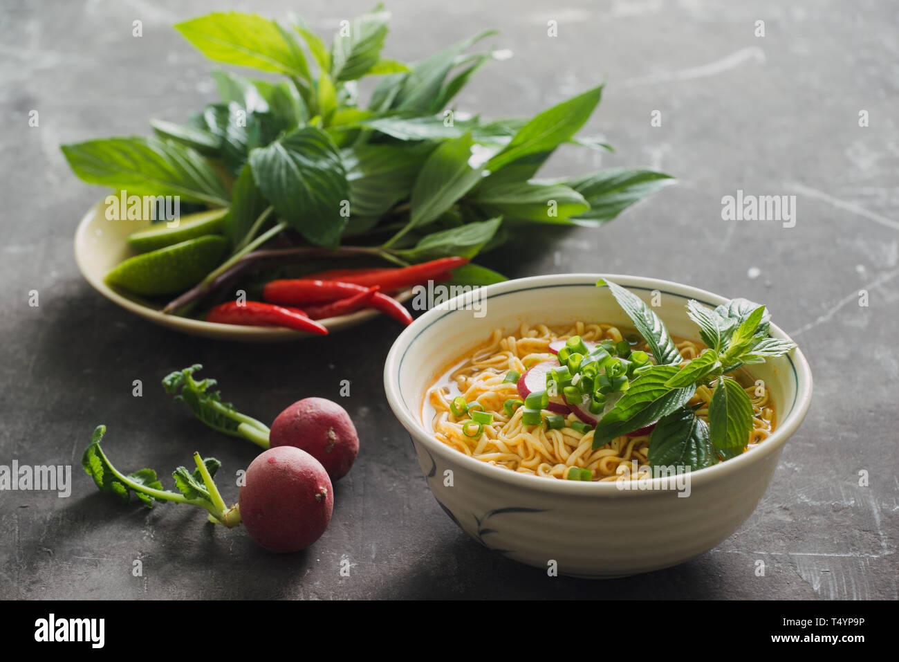 Instant noodles in bowl with fresh herbs, garnish of cilantro and Asian ...