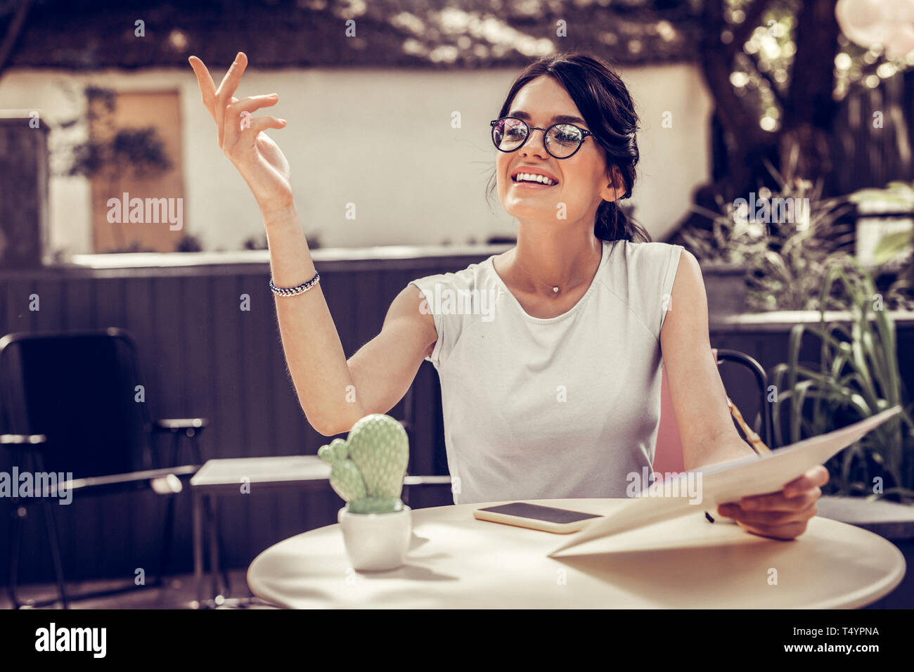 Nice beautiful woman calling for a waitress Stock Photo - Alamy