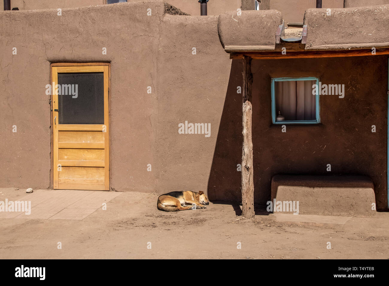 Mud adobe pueblo building in American southwest with new wooden door ...