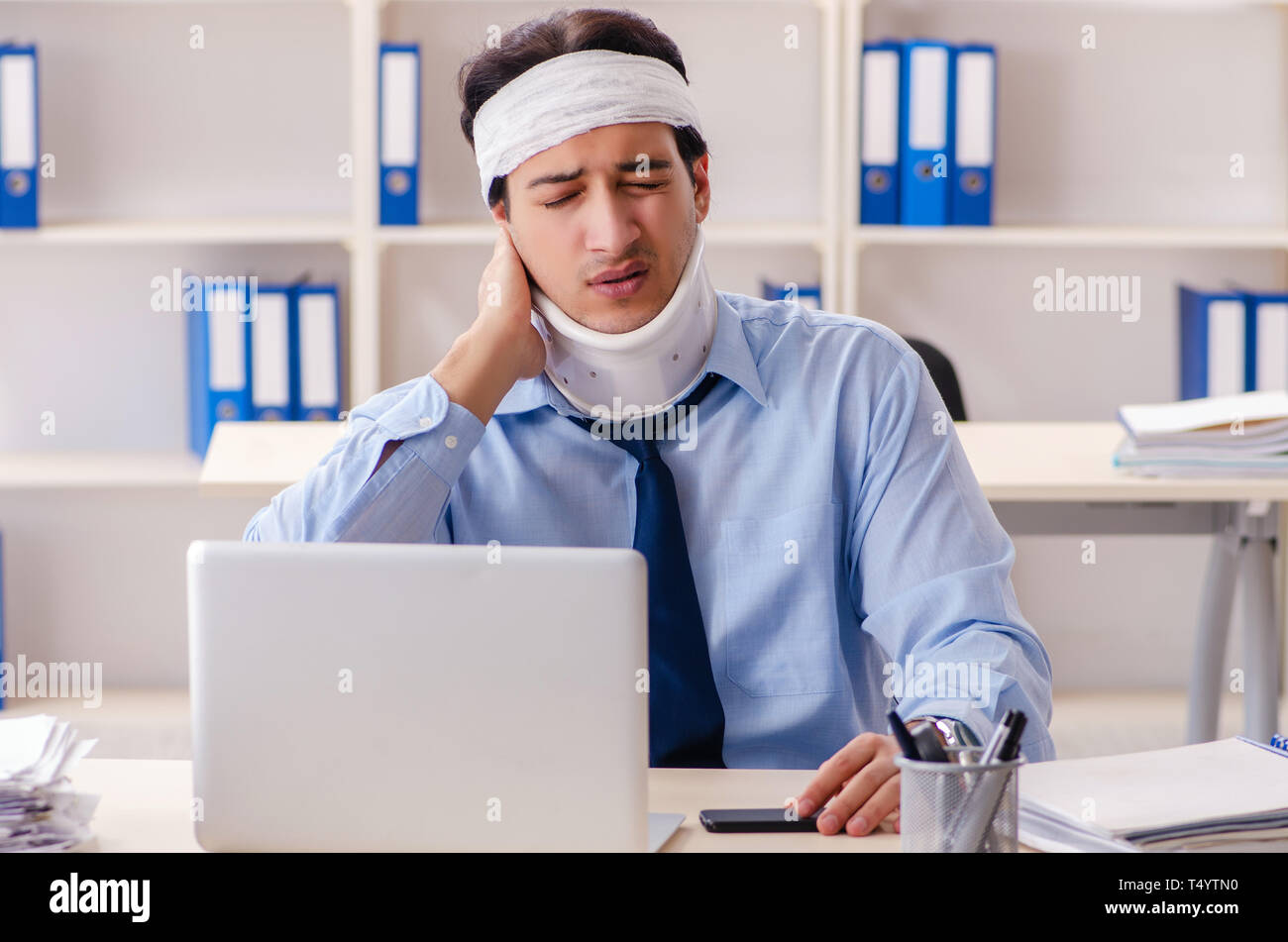 Young injured male employee working in the office Stock Photo - Alamy