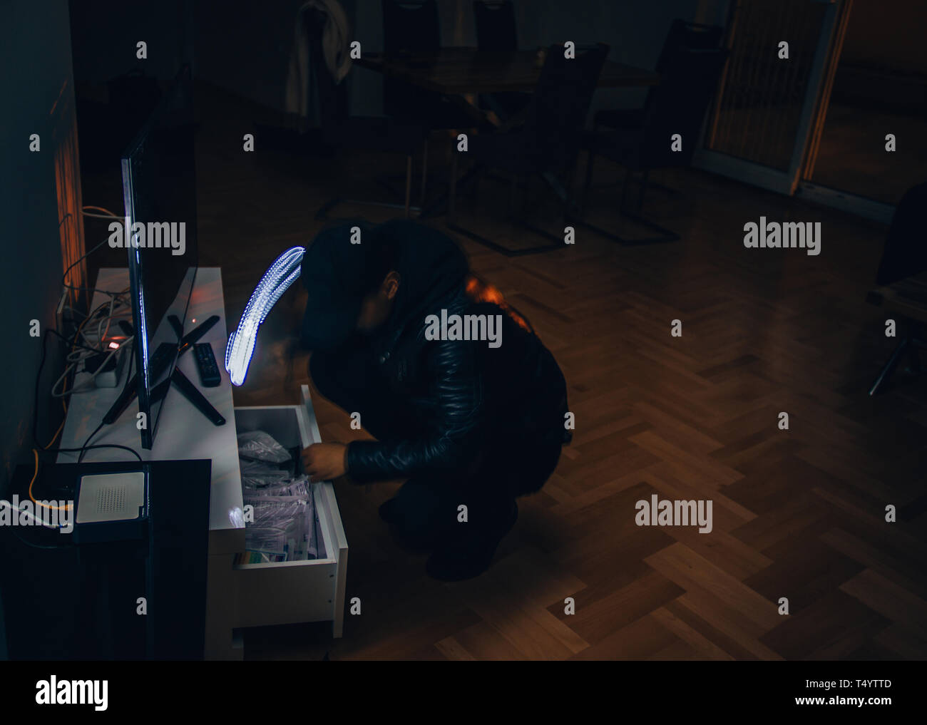 Intruder with flashlight stealing documents from the desk Stock Photo ...