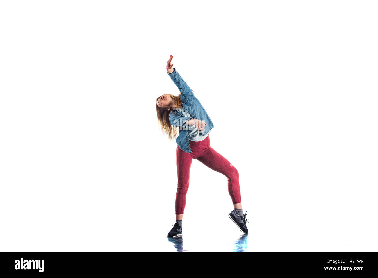 Fitness girl is isolated in a room with white background and she is ...