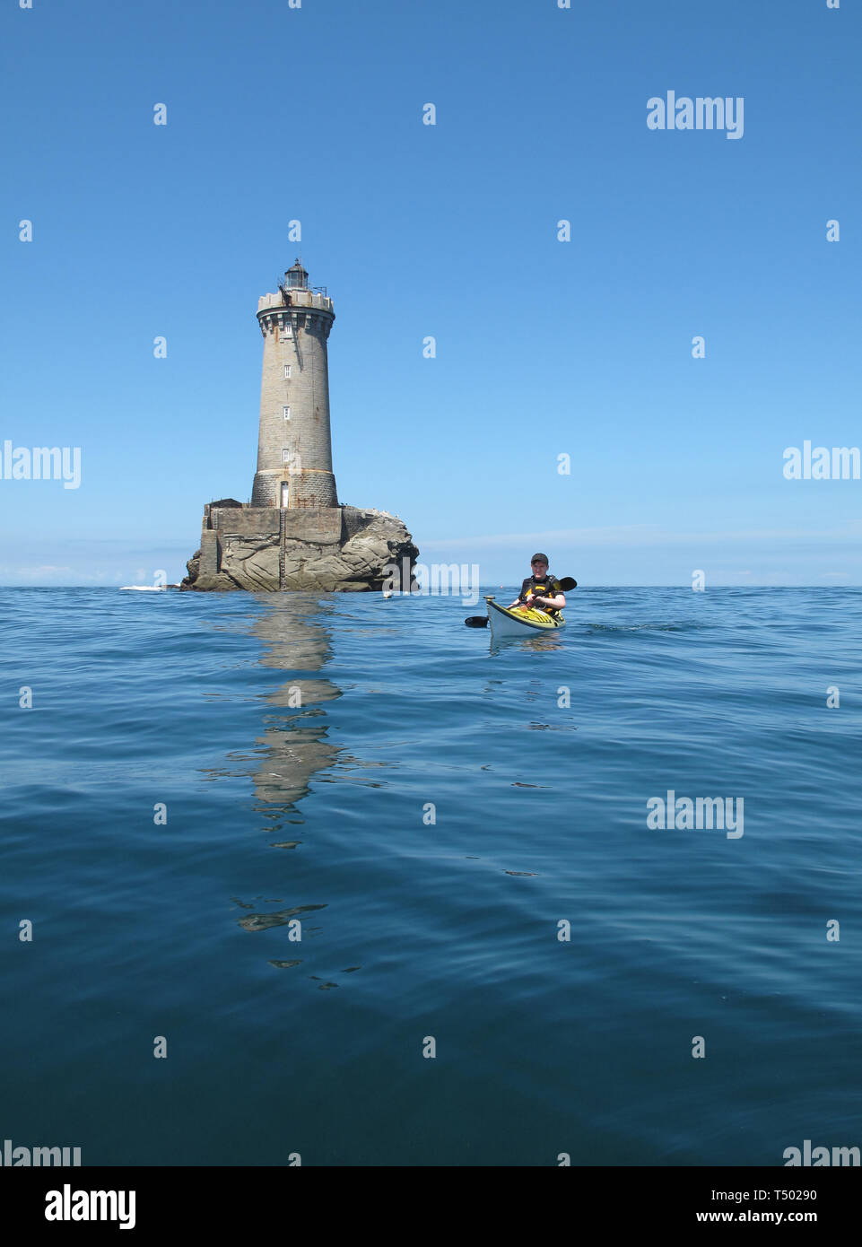 One Kayaker paddling towards Le Four lighthouse, Finisterre, Brittany ...