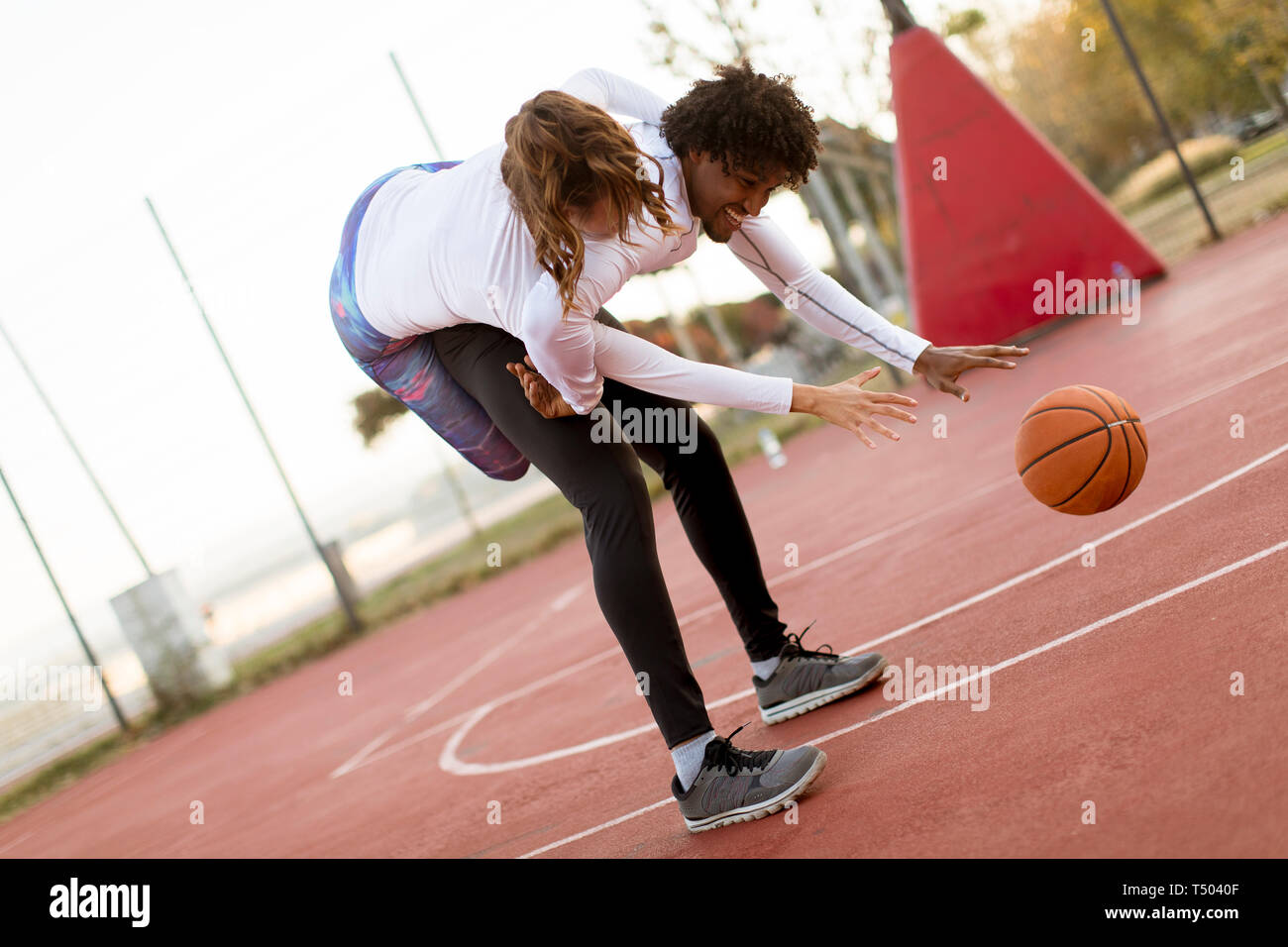 Multiracial couple playing basketball at court Stock Photo - Alamy
