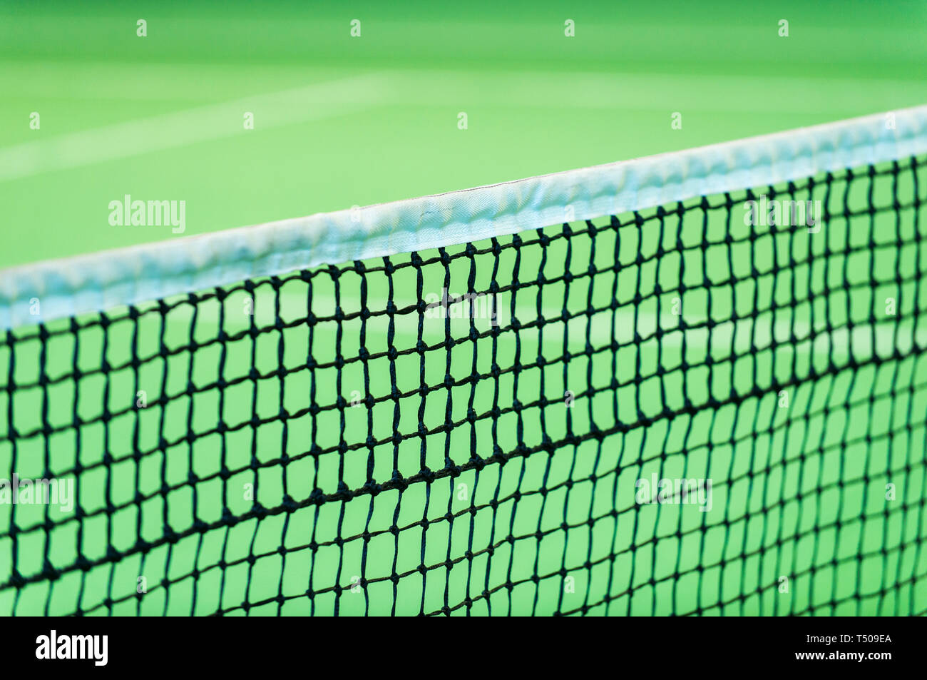 Net of tennis court on green wall background Stock Photo - Alamy