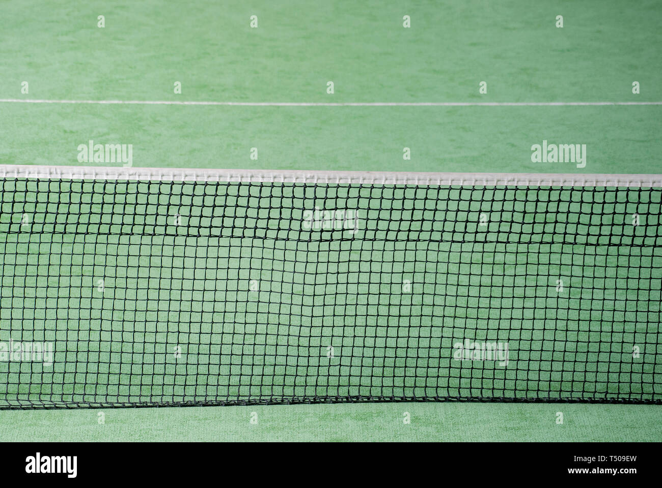 Net of tennis court on green wall background Stock Photo - Alamy