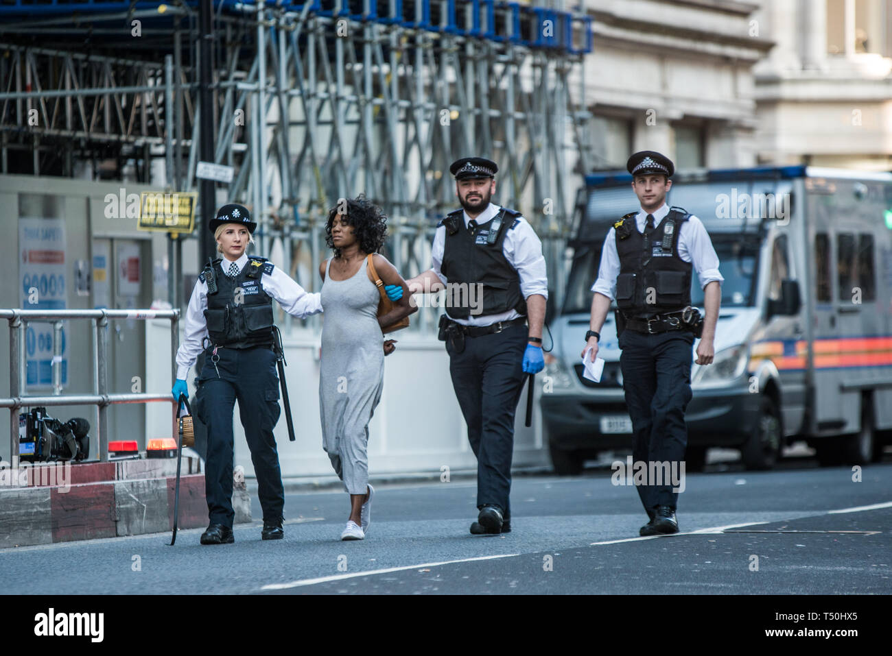 A woman getting arrested by police officers during the Extinction ...
