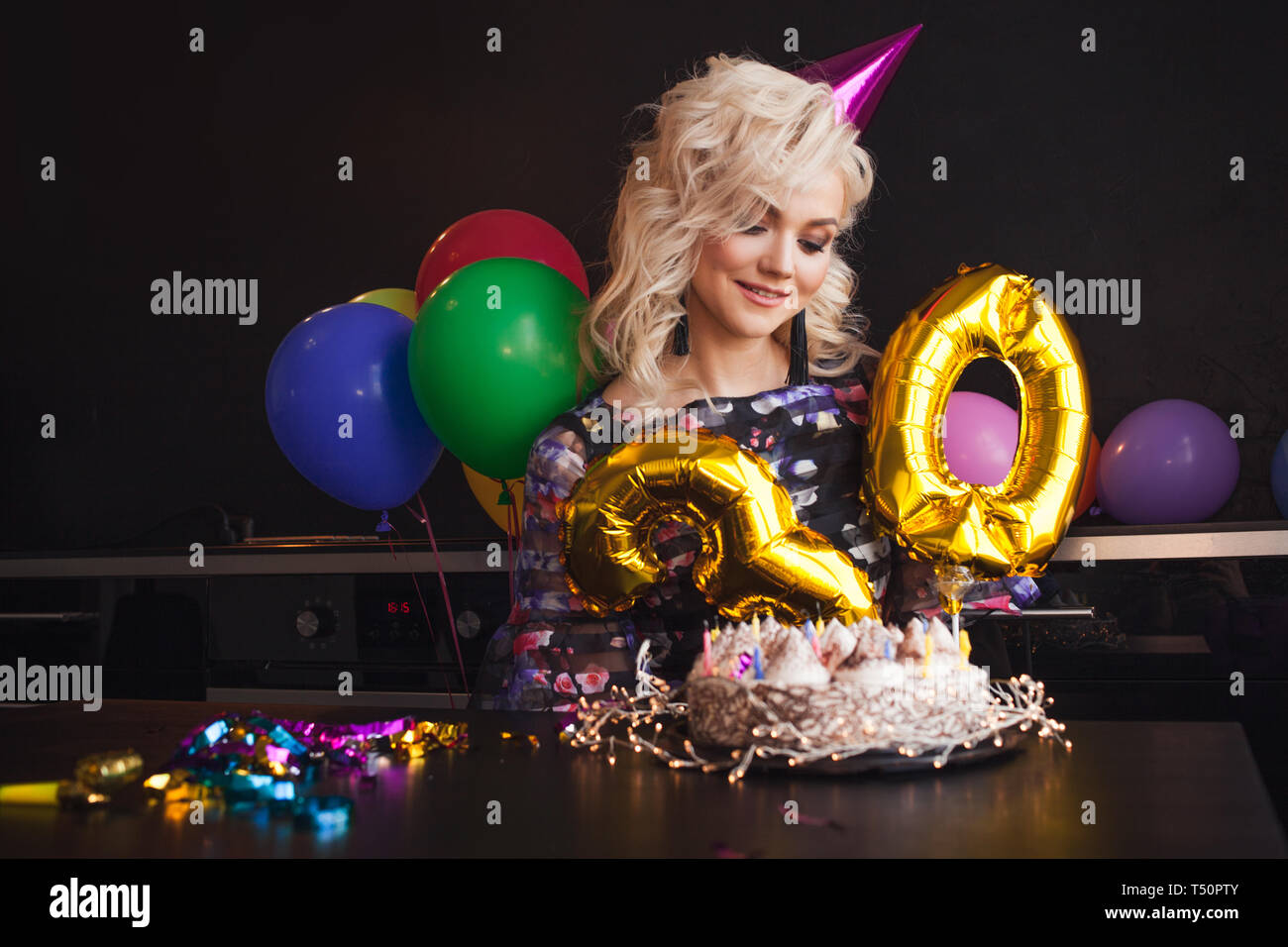 Happy young woman having fun at birthday party. Birthday girl with ...