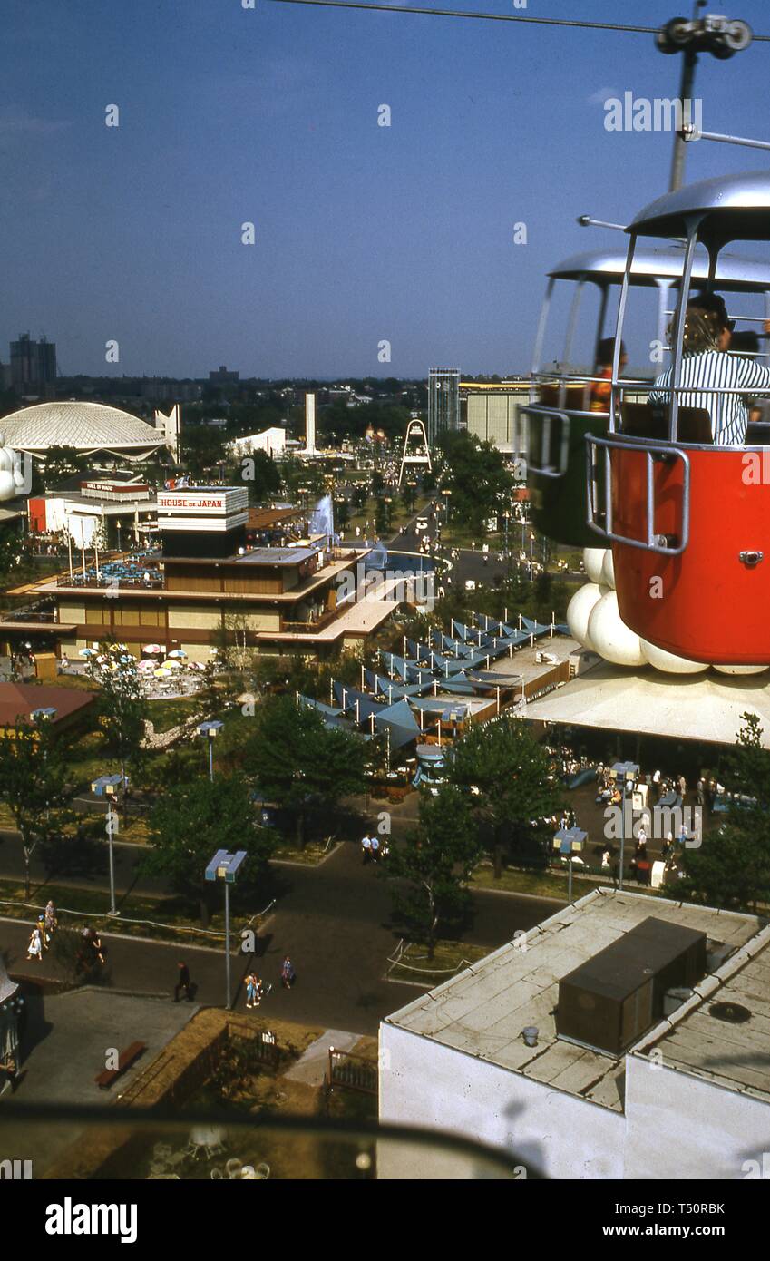 Bird's-eye view, on a sunny day, of people riding in Swiss Sky Ride gondolas above various ...