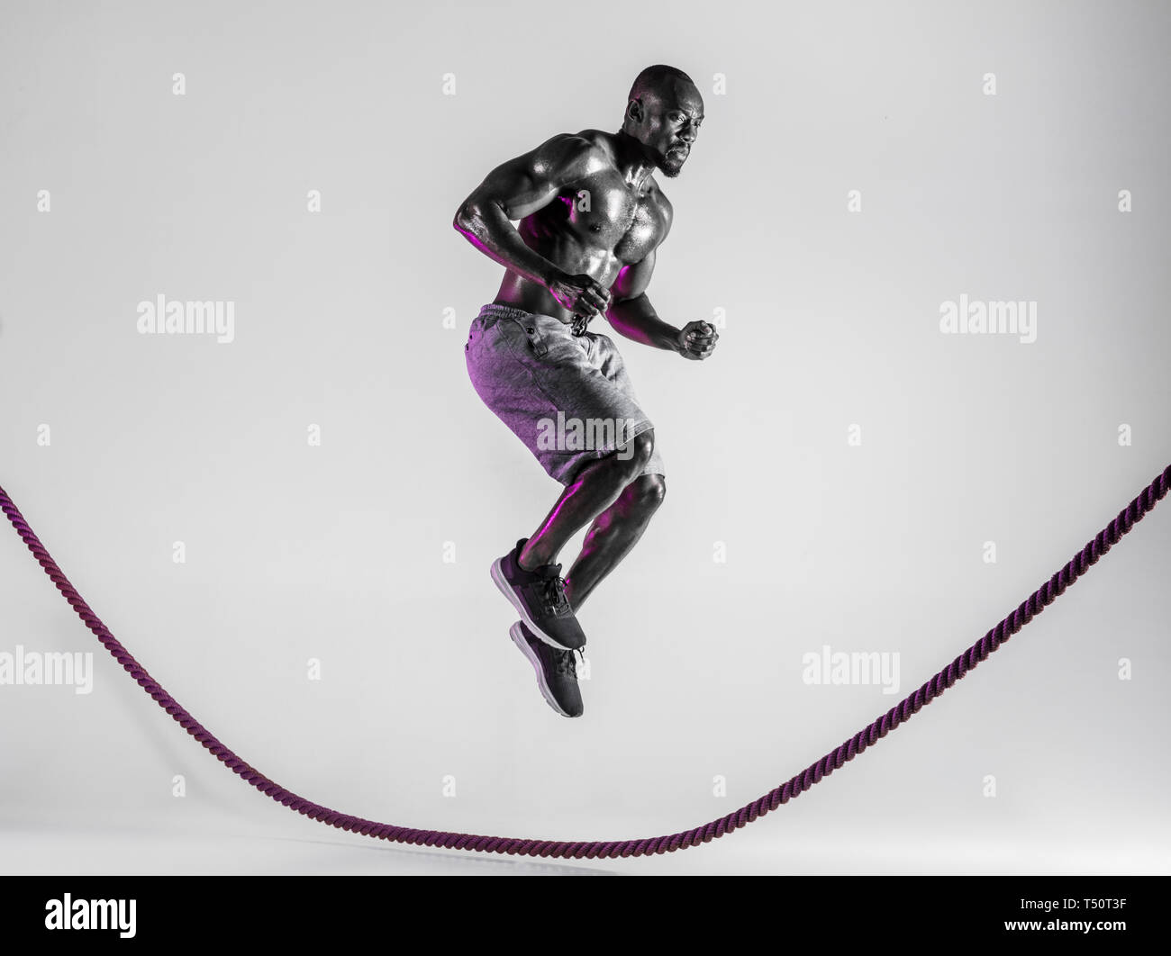 Above the world. Young african-american bodybuilder training on grey ...