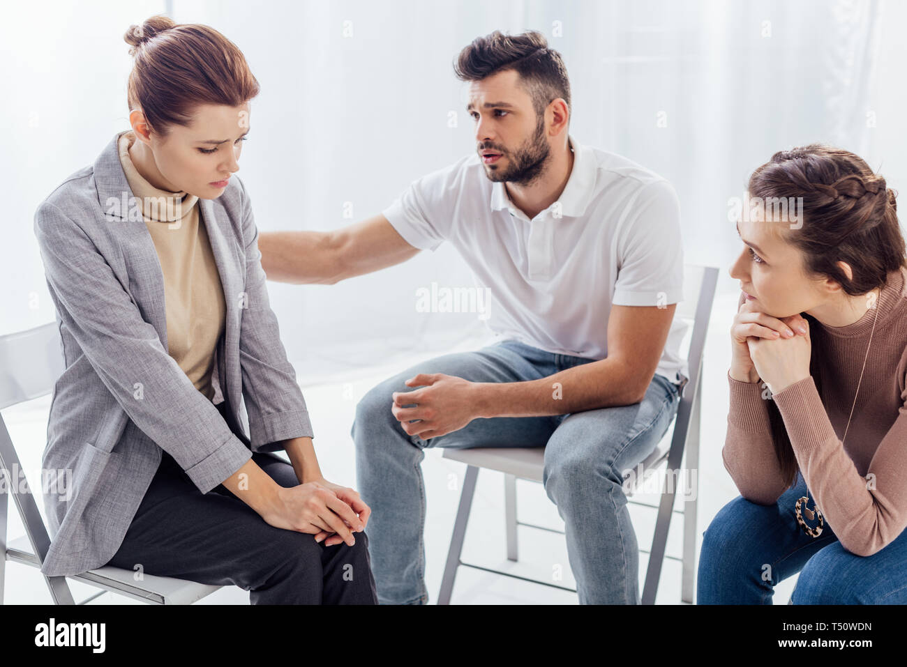 man consoling sad woman during group therapy session Stock Photo - Alamy