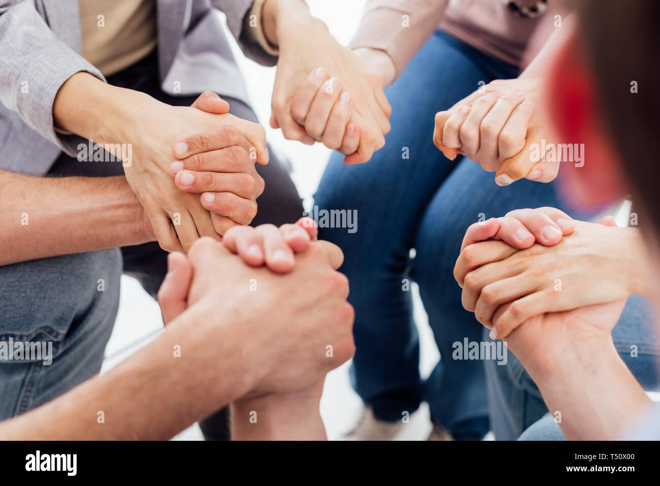 cropped view of people holding hands during group therapy session Stock ...