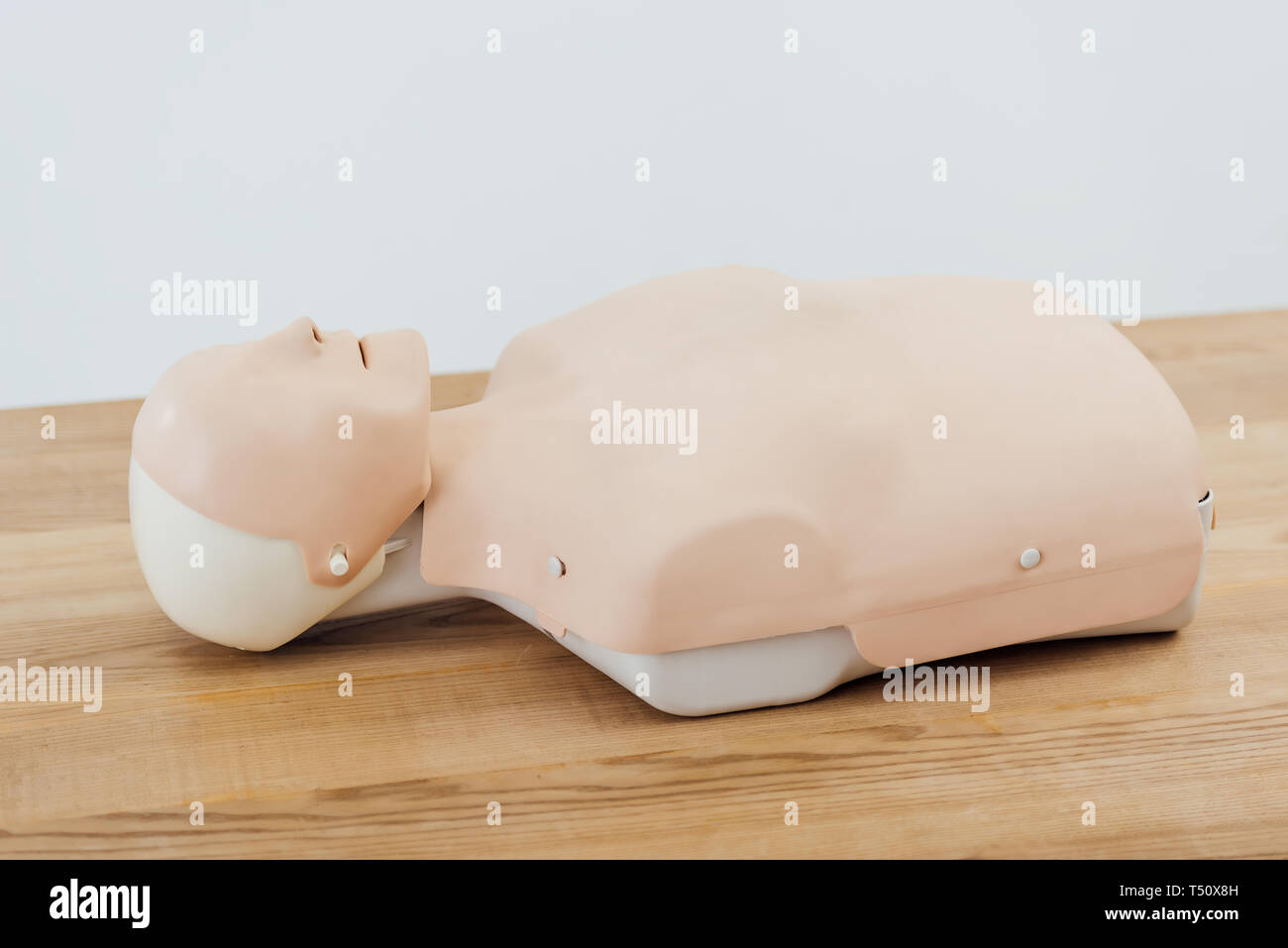 cpr dummy for first aid training on wooden table isolated on grey with ...