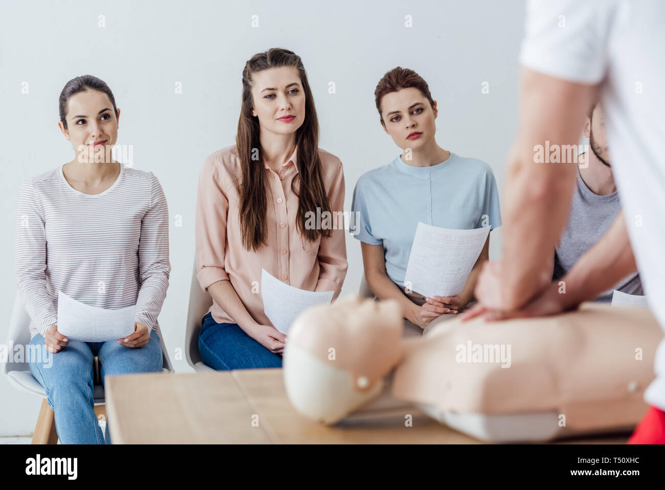 instructor performing chest compression on dummy during cpr training ...