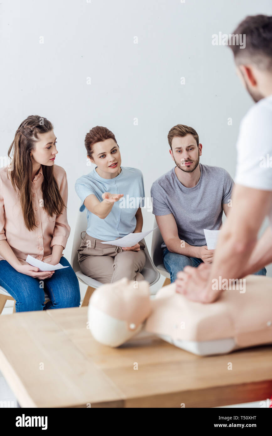 instructor performing chest compression on dummy during cpr training ...