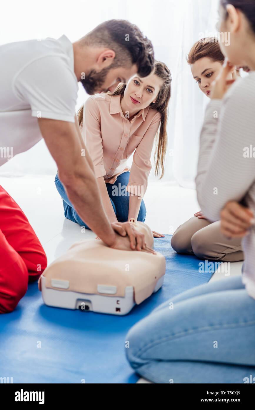 selective focus of instructor performing cpr on dummy during first aid ...