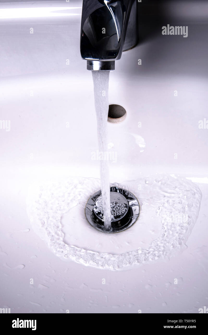 Water flows into the sink with drain plug Stock Photo - Alamy