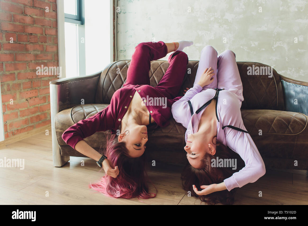 LGBT Cute young girls smiling and flirting on sofa at home Stock Photo ...