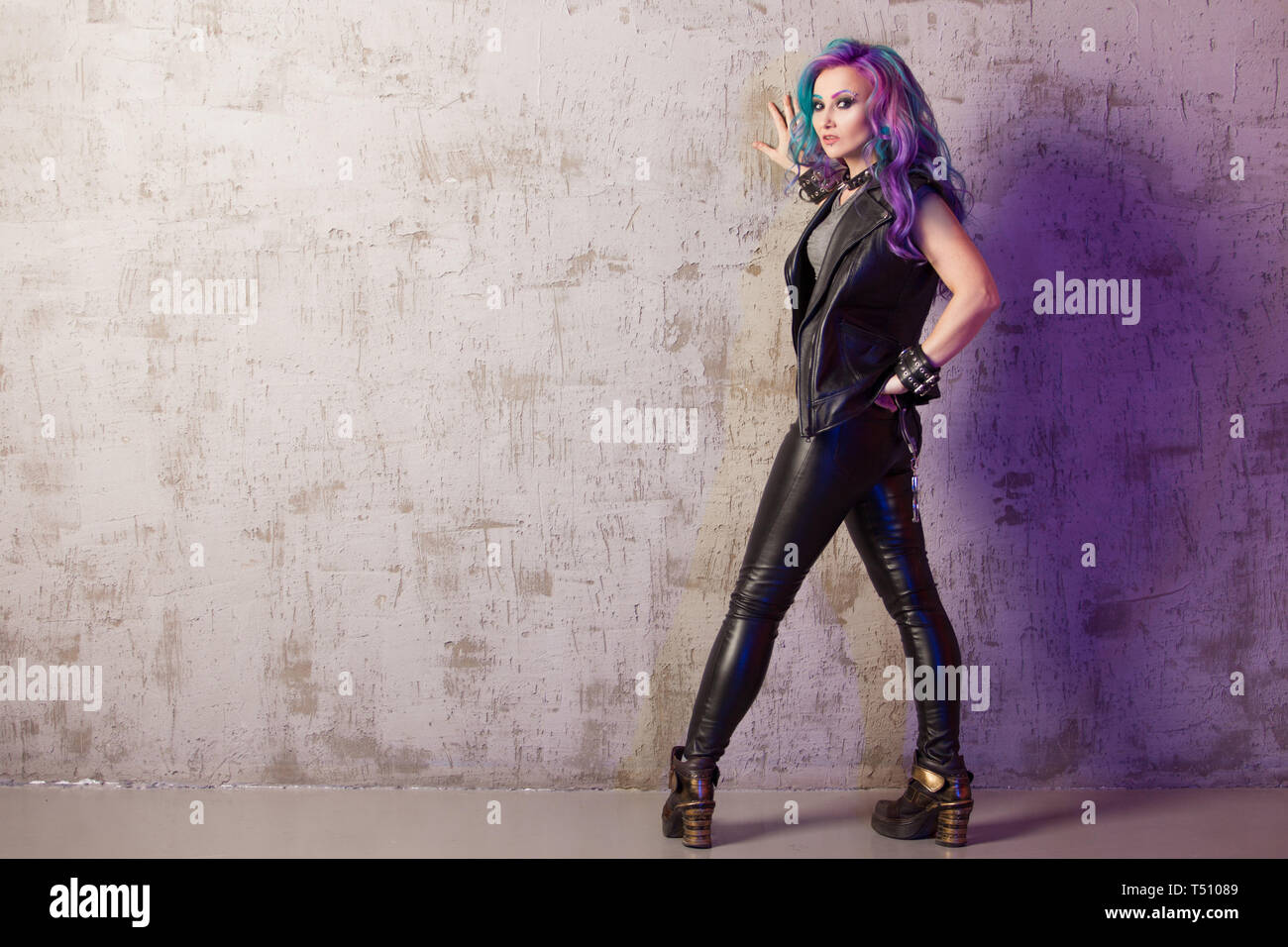 Daring rebel rocker, a portrait on a background of gray grunge wall ...