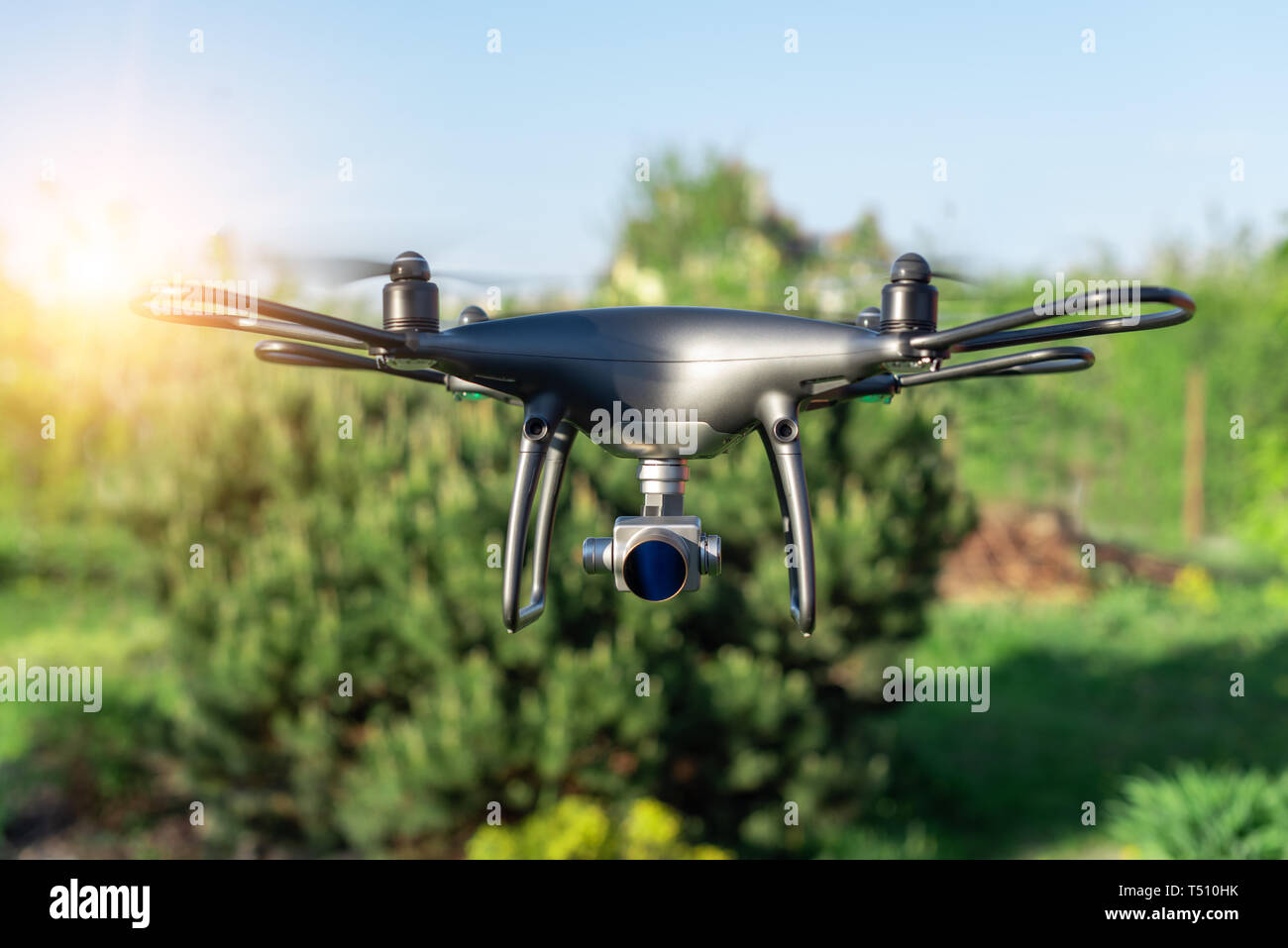 Dark drone flying through the air in the sun Stock Photo - Alamy