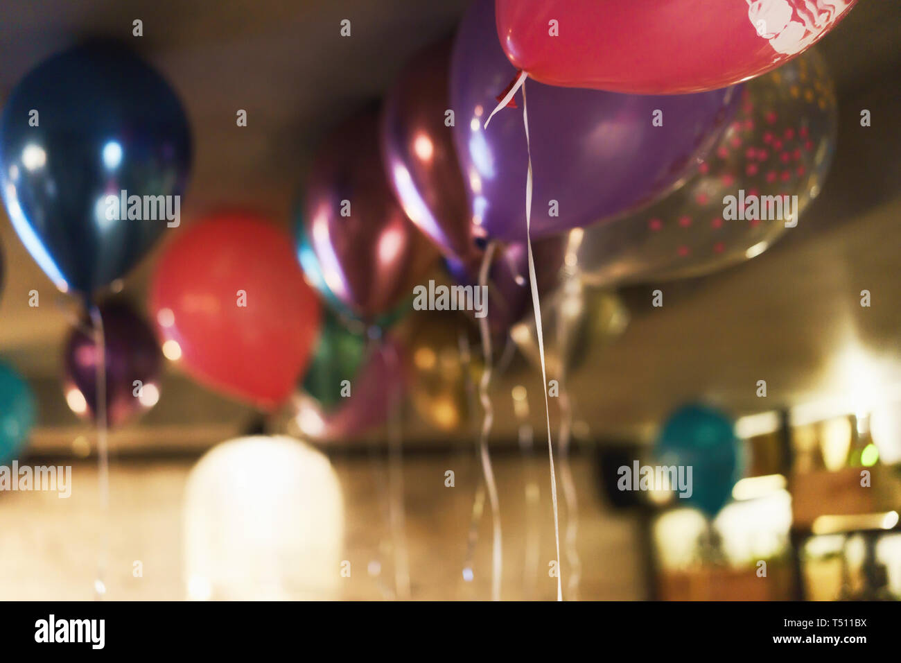 Blurred background with multicolored balloons under the ceiling ...
