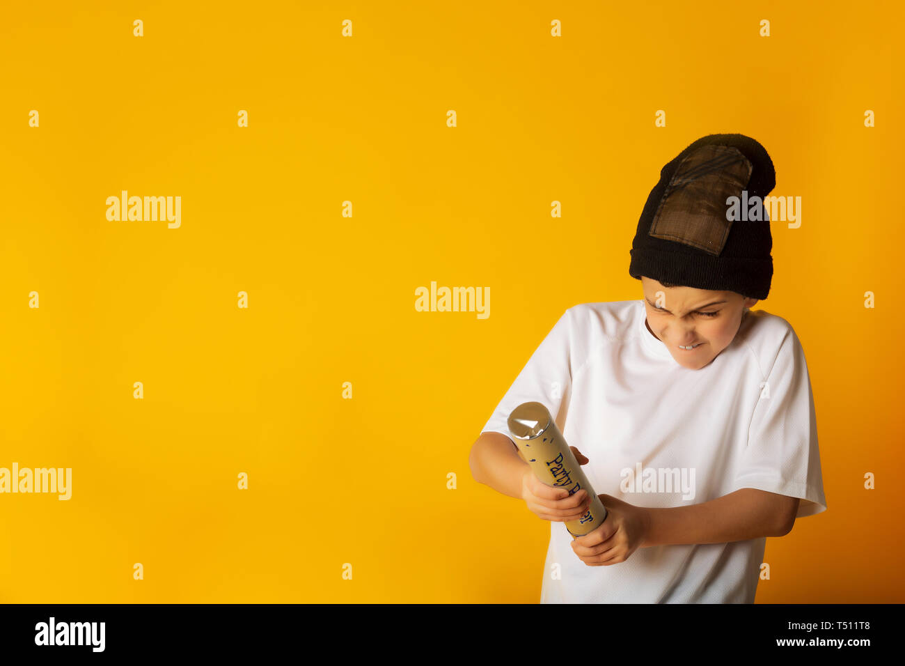 Boy shoots a confetti into the air against a yellow background Stock ...