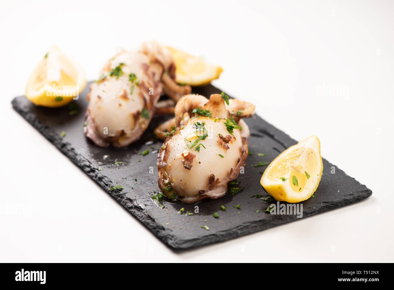 Delicious BBQ cuttle fish on a stone dish isolated on white Stock Photo ...